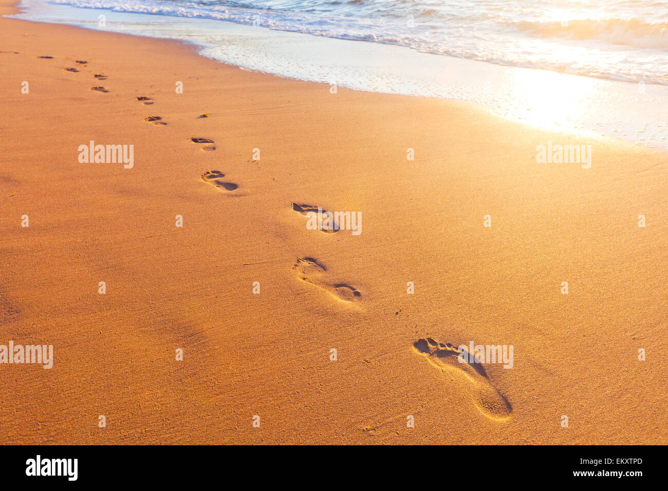 beach, wave and footsteps at sunset time Stock Photo - Alamy