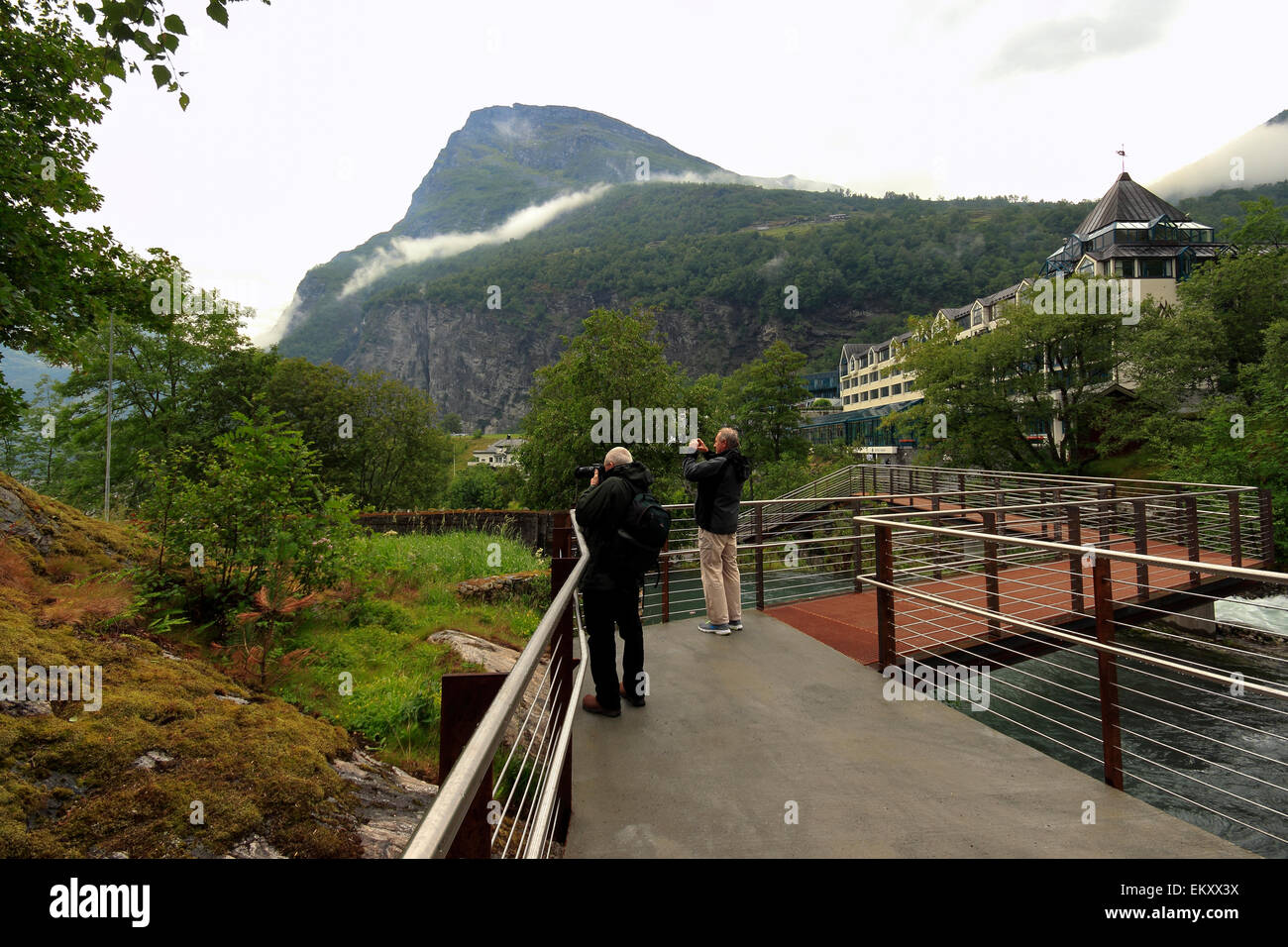 Tourists photographing the scenery along a riverwalk, Geiranger, Norway ...