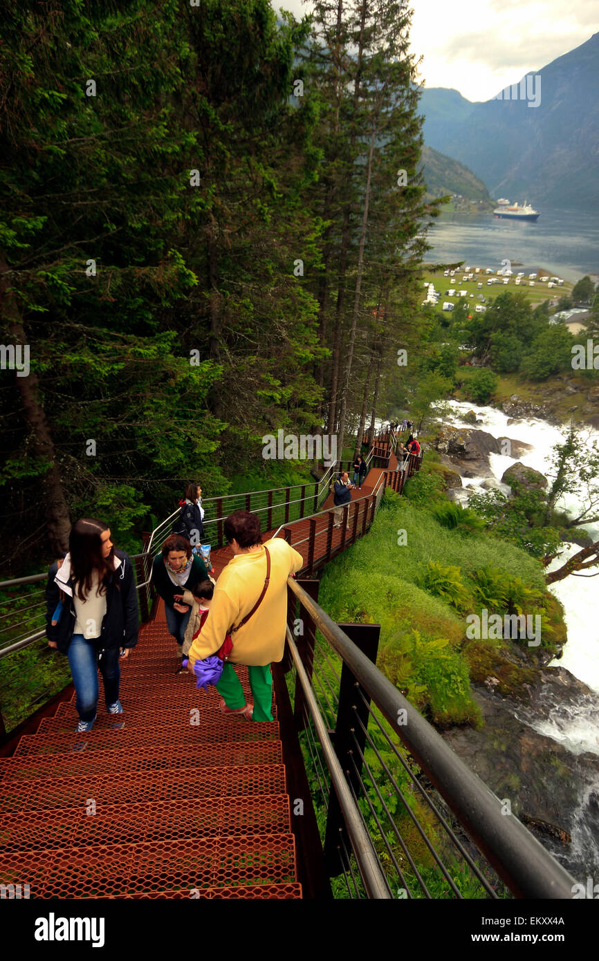 Tourists along a riverwalk, Geiranger, with a cruise ship on the ...
