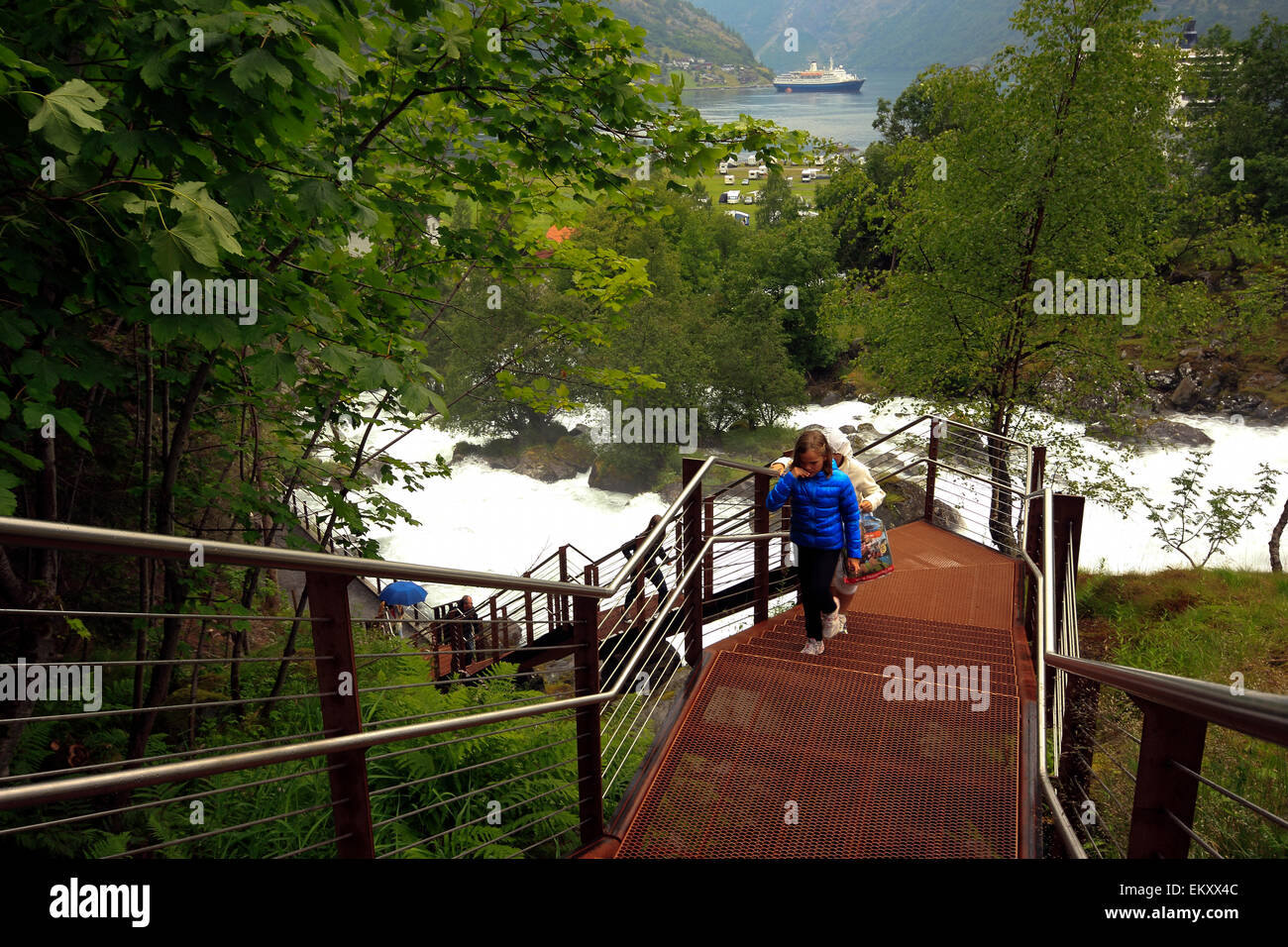 Tourists along a riverwalk, Geiranger, with a cruise ship on the ...