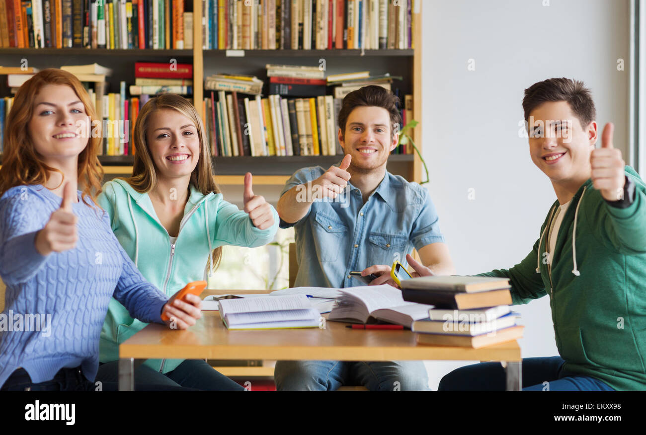 students with books showing thumbs up in library Stock Photo - Alamy