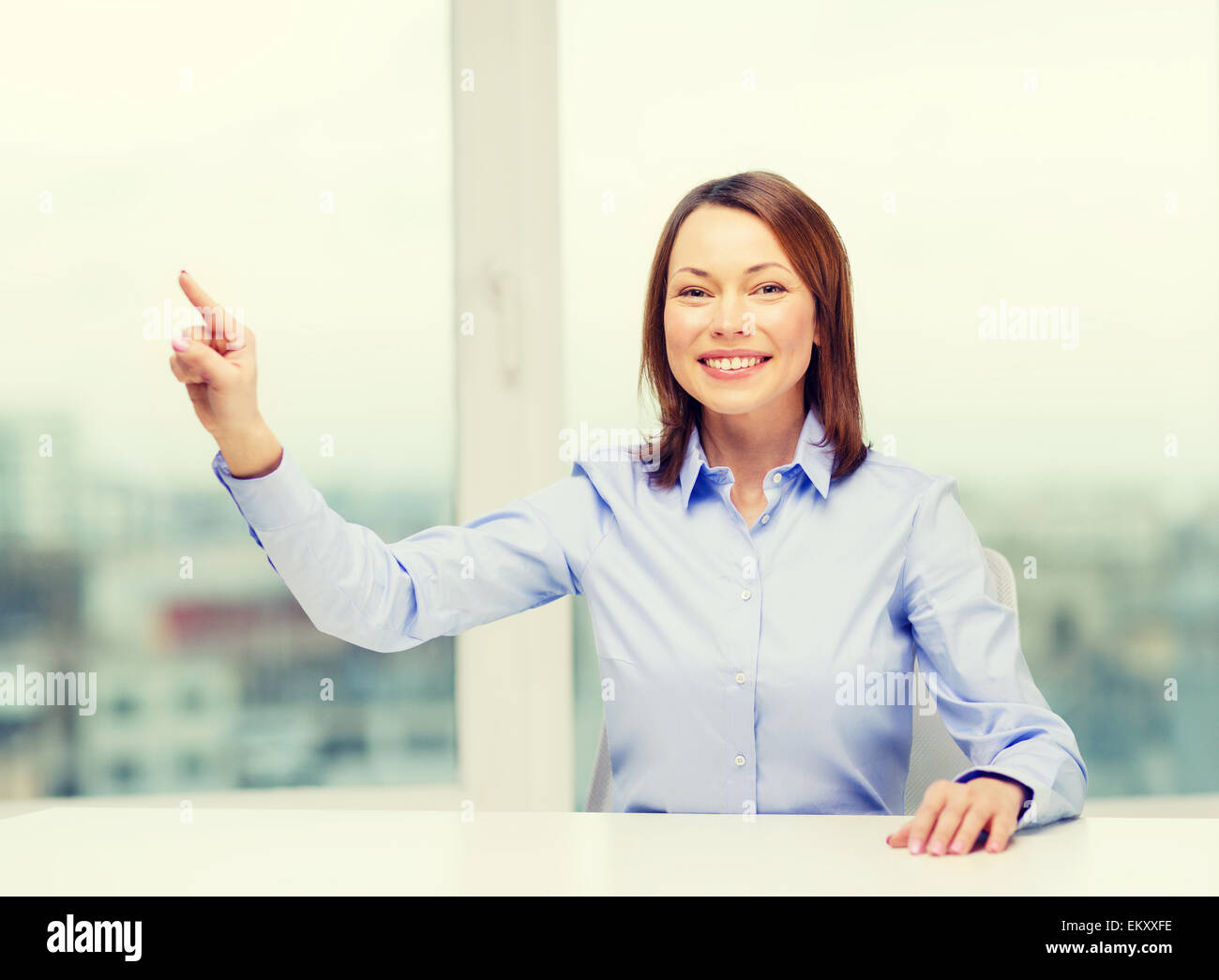 smiling woman pointing to something imaginary Stock Photo - Alamy