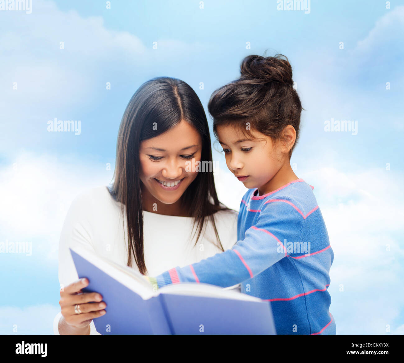 happy mother and daughter reading book Stock Photo - Alamy