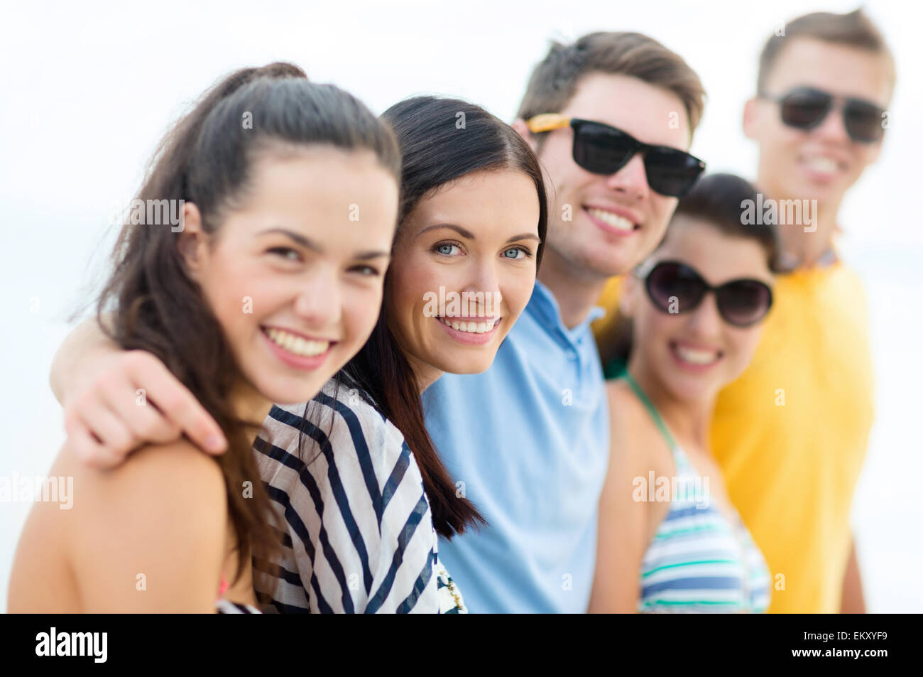 group of happy friends hugging on beach Stock Photo - Alamy