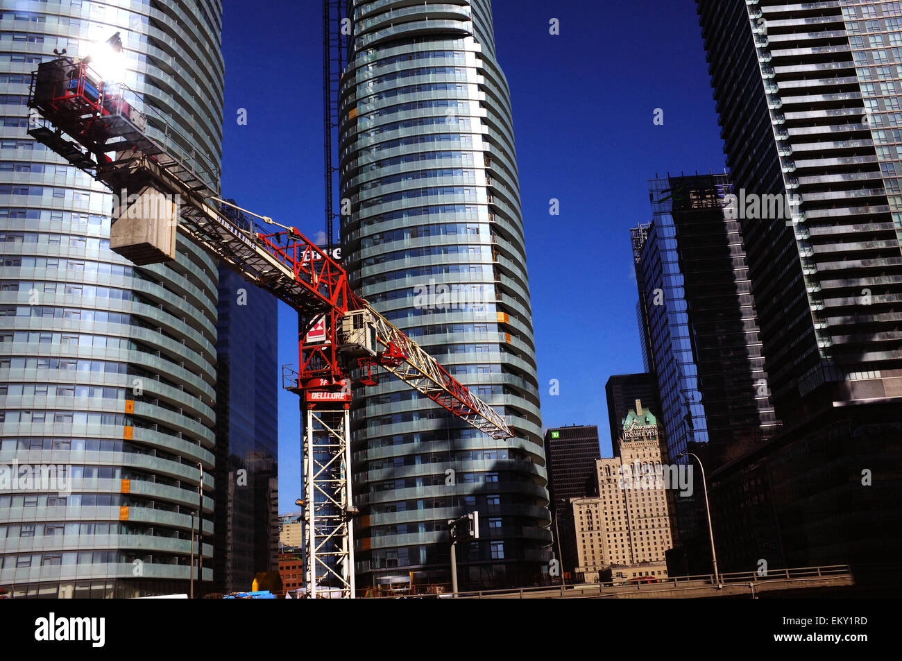 A red tower crane amidst a group of high rise buildings in the centre ...
