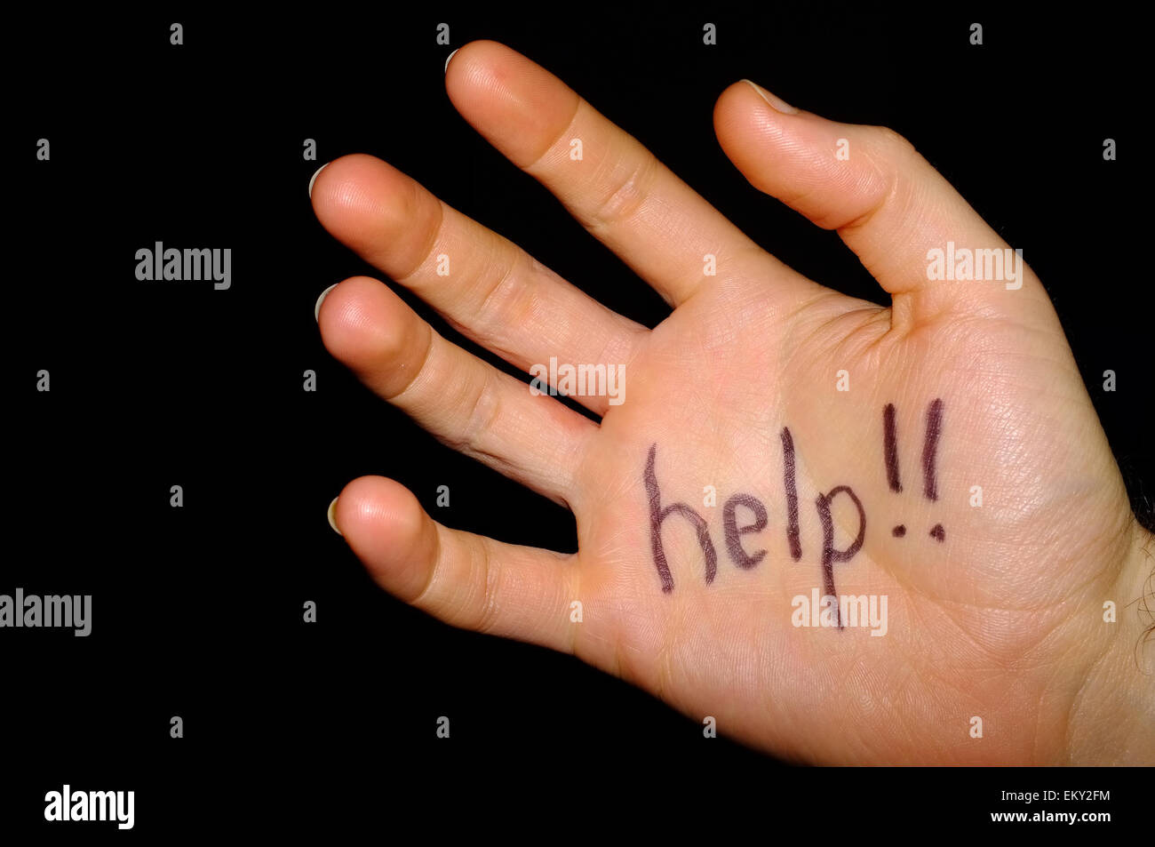 Help!! written on a white man's hand photographed against a black ...