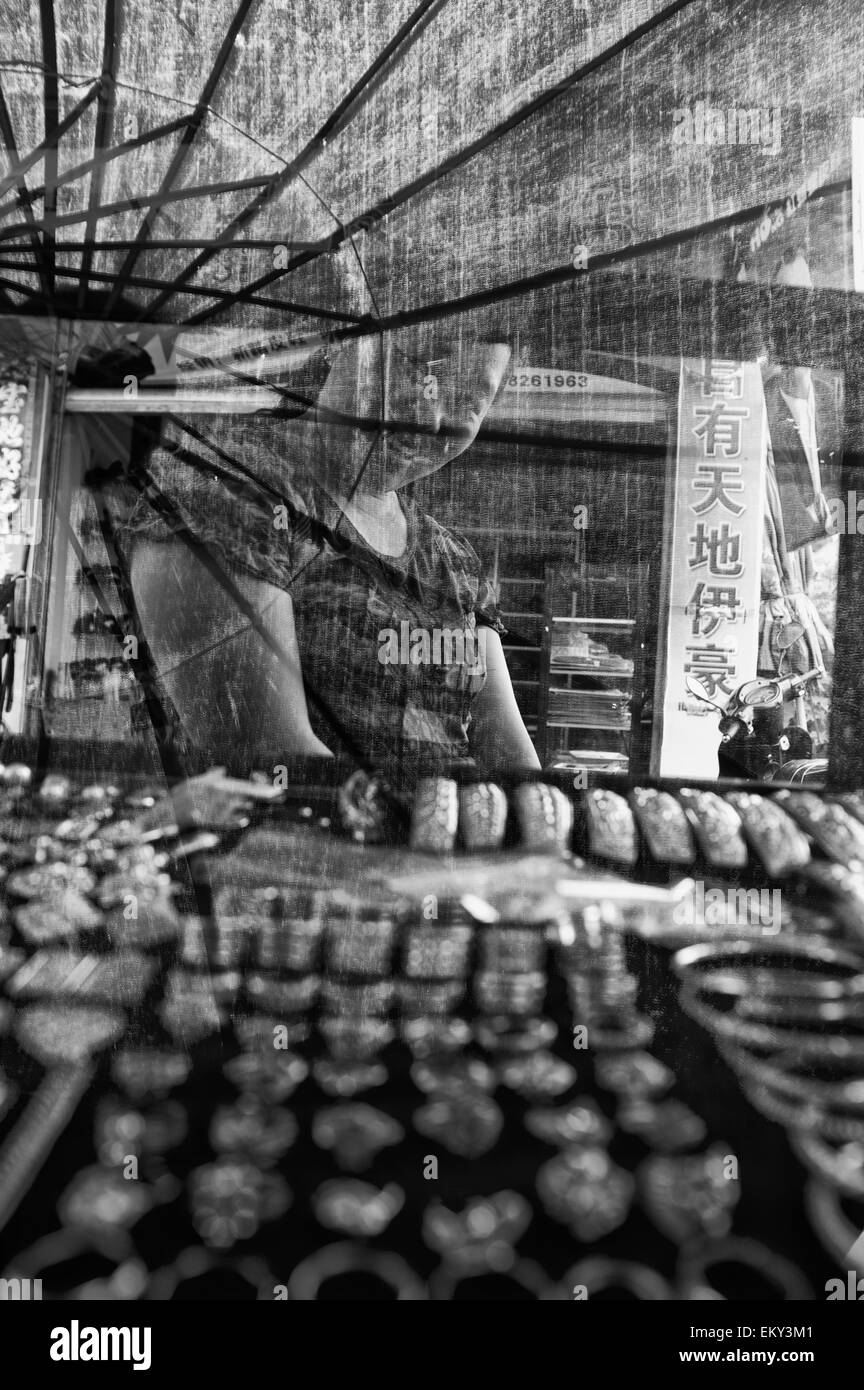 A Female Vendor Smiles Behind A Screen Where Jewelry Is Displayed ...
