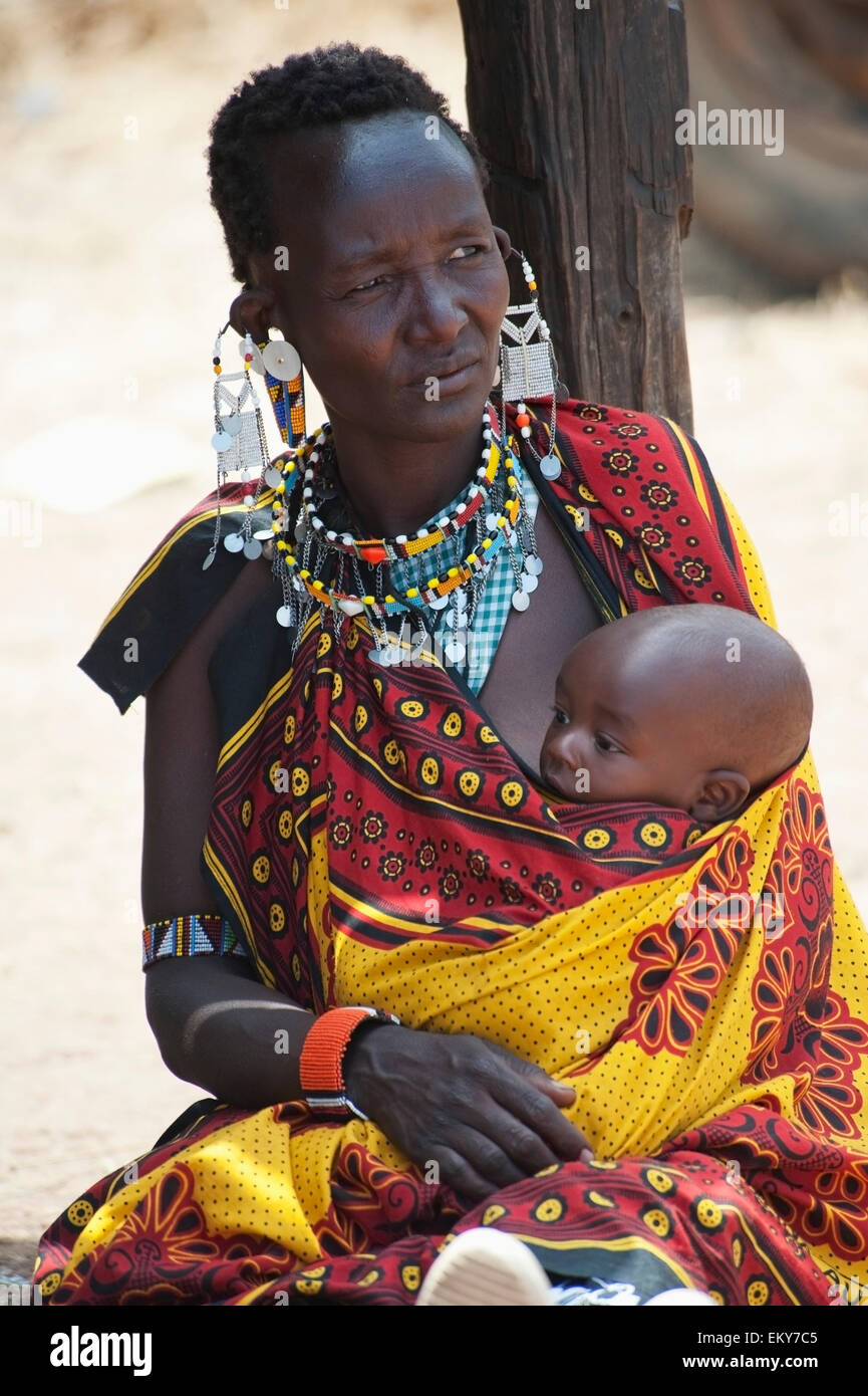 Samburu tribe woman holding her baby close to her with colorful fabric ...