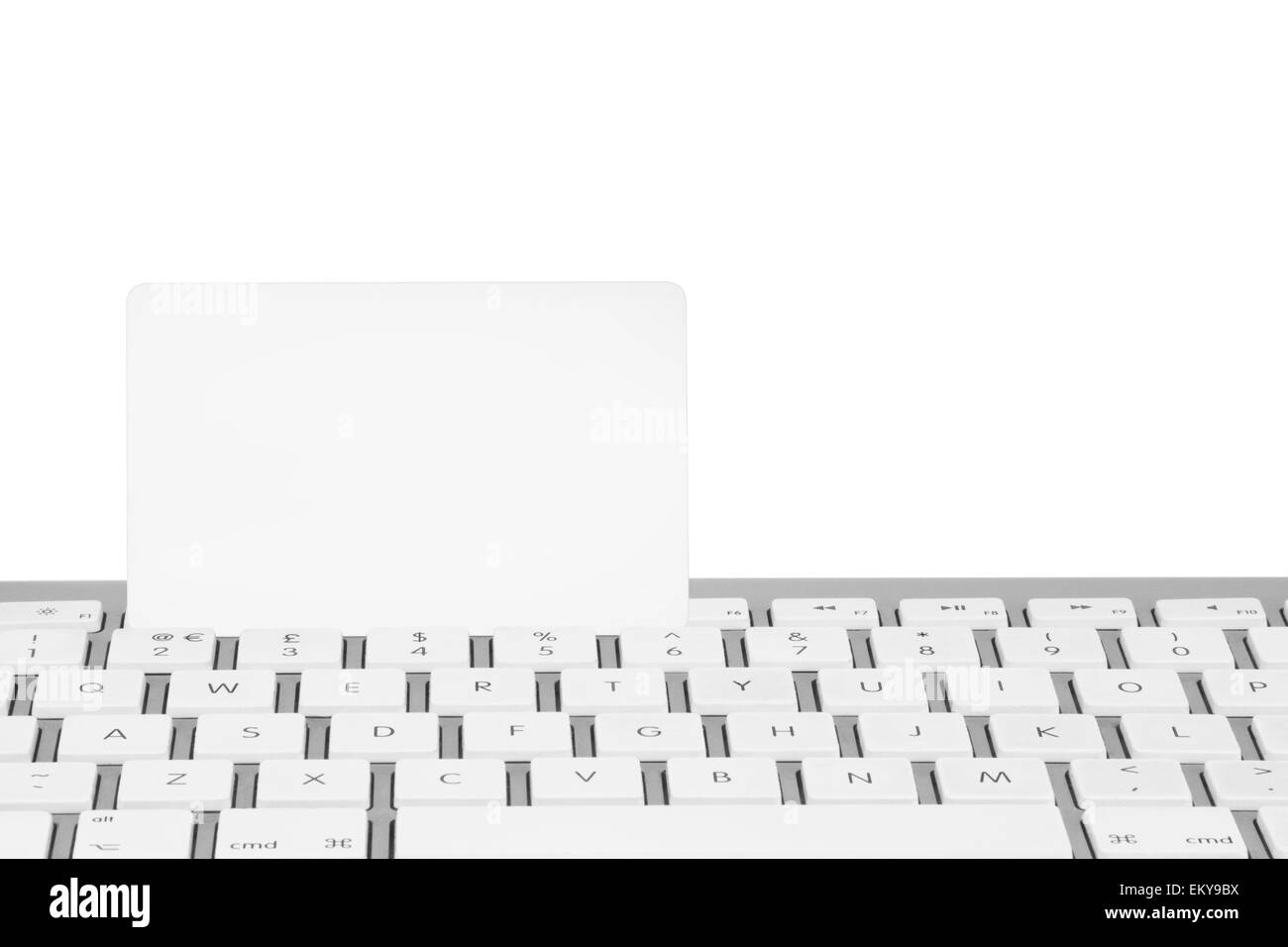 Blank white bank card on a computer keyboard with a white background ...