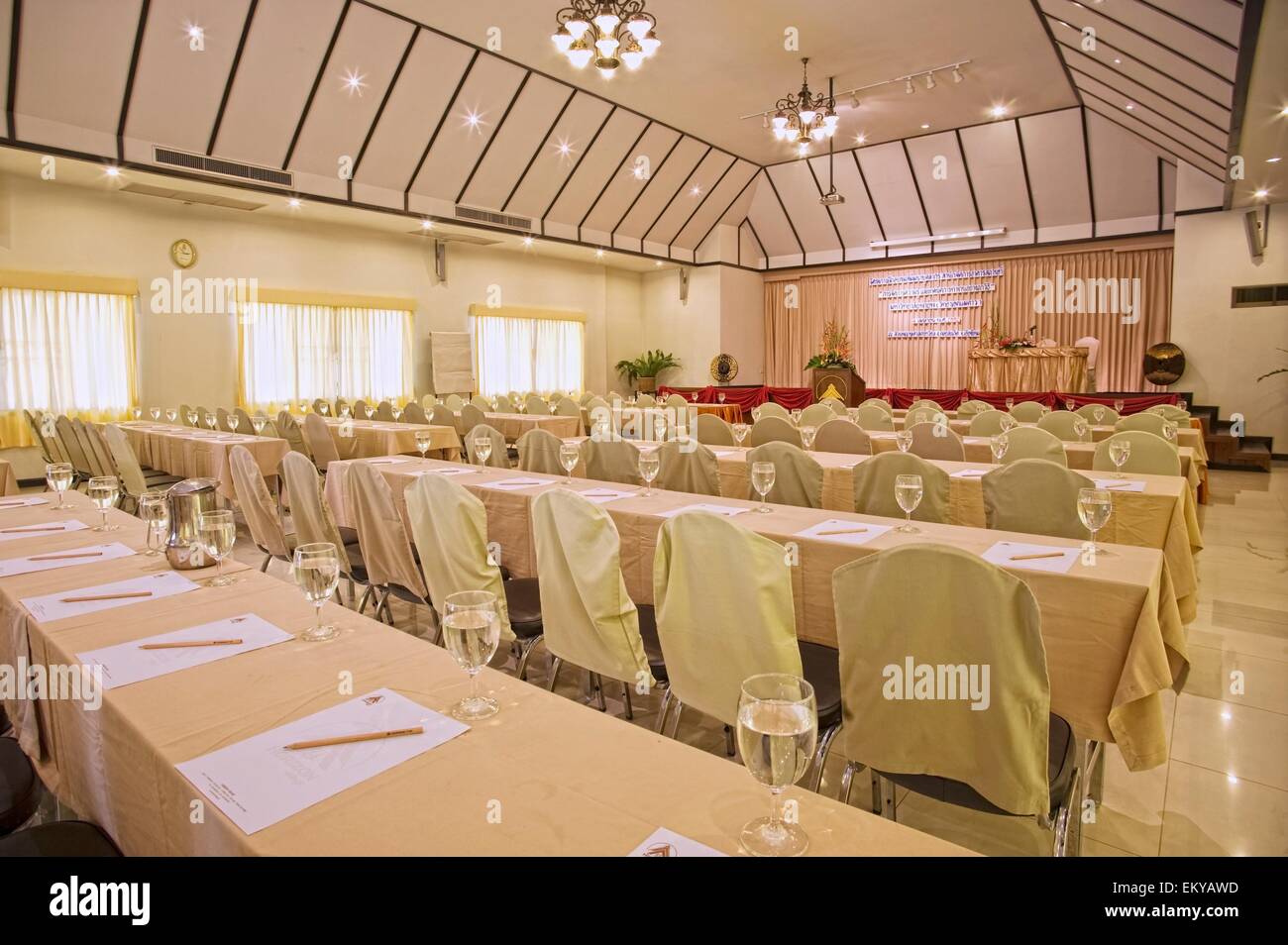 A Room Set Up With Tables And Chairs In A Row Facing A Platform Stock ...