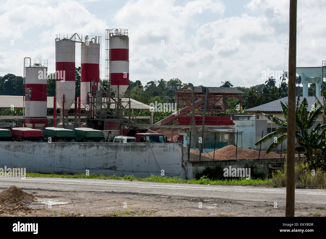 Derelict looking but working factory with red and white chimneys and ...