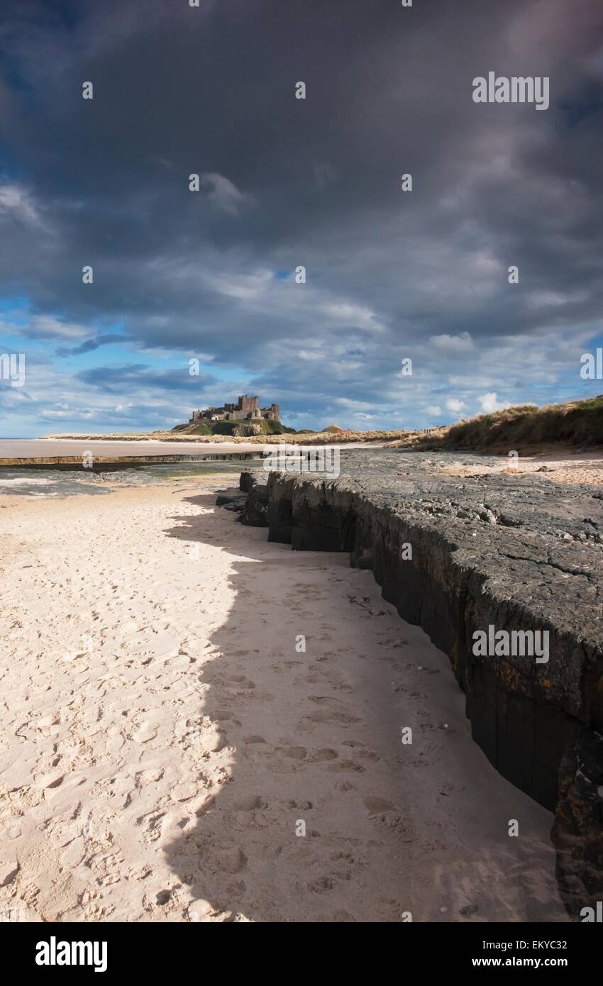 Sand Along A Rock Ledge With Dark Clouds In The Sky; Bamburgh ...