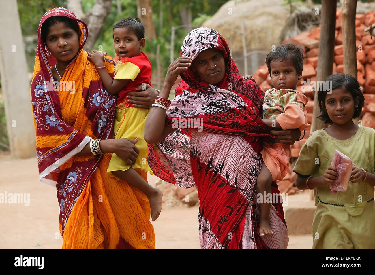 Mothers and their children walking down a village road; Ratapata ...