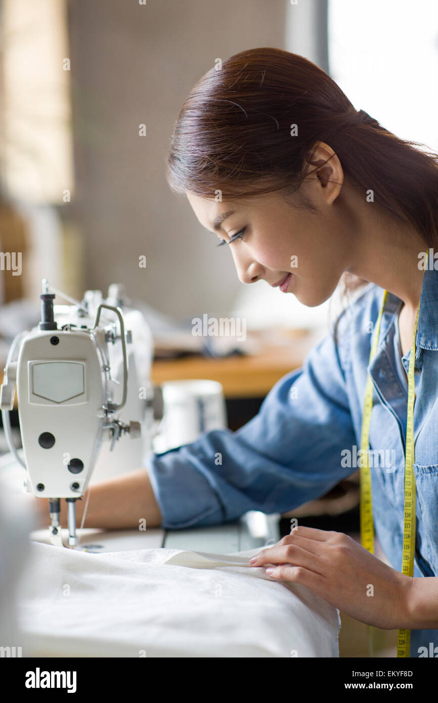 Fashion designer using sewing machine Stock Photo - Alamy