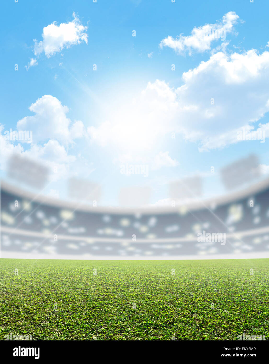 A generic sports stadium with a marked green grass pitch in the daytime ...