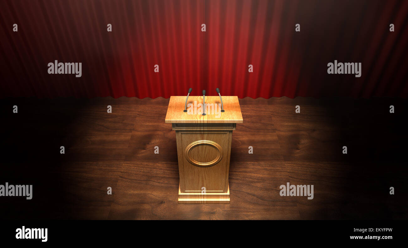 A regular theater stage with closed red curtains and a wooden debate ...