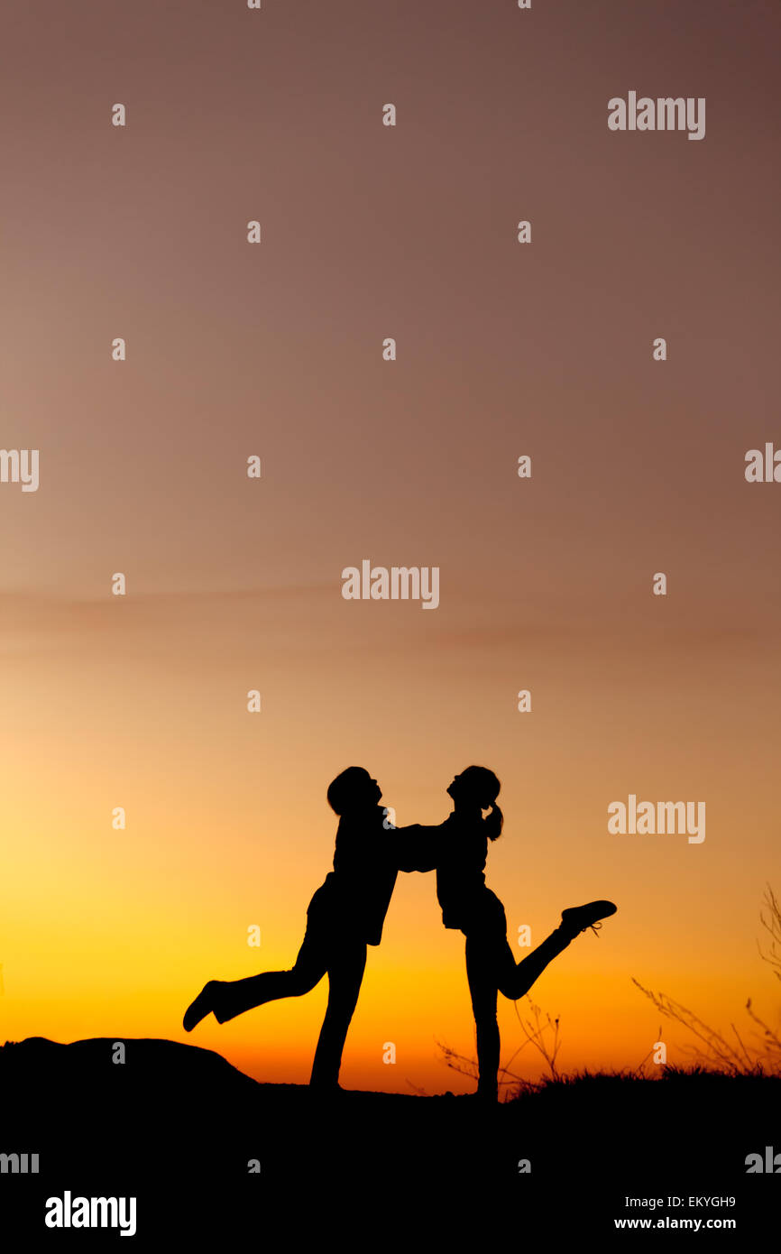 Silhouettes Of Mother And Daughter At The Beautiful Sunset Dusk