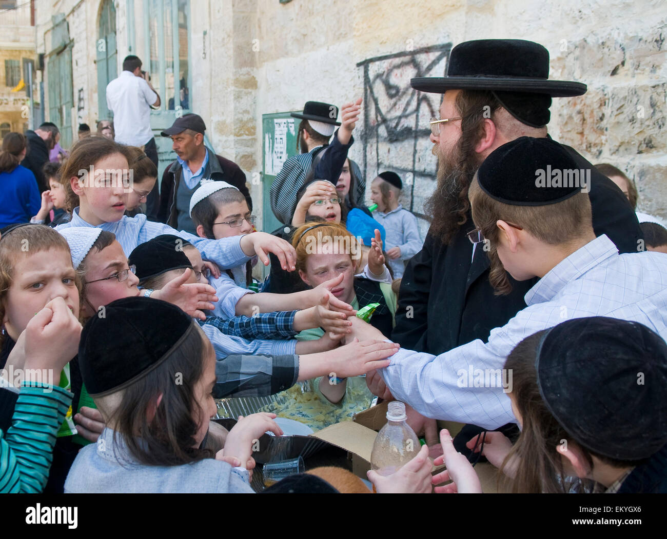 An Ultra Orthodox Jew man handing out food to poor children in ...