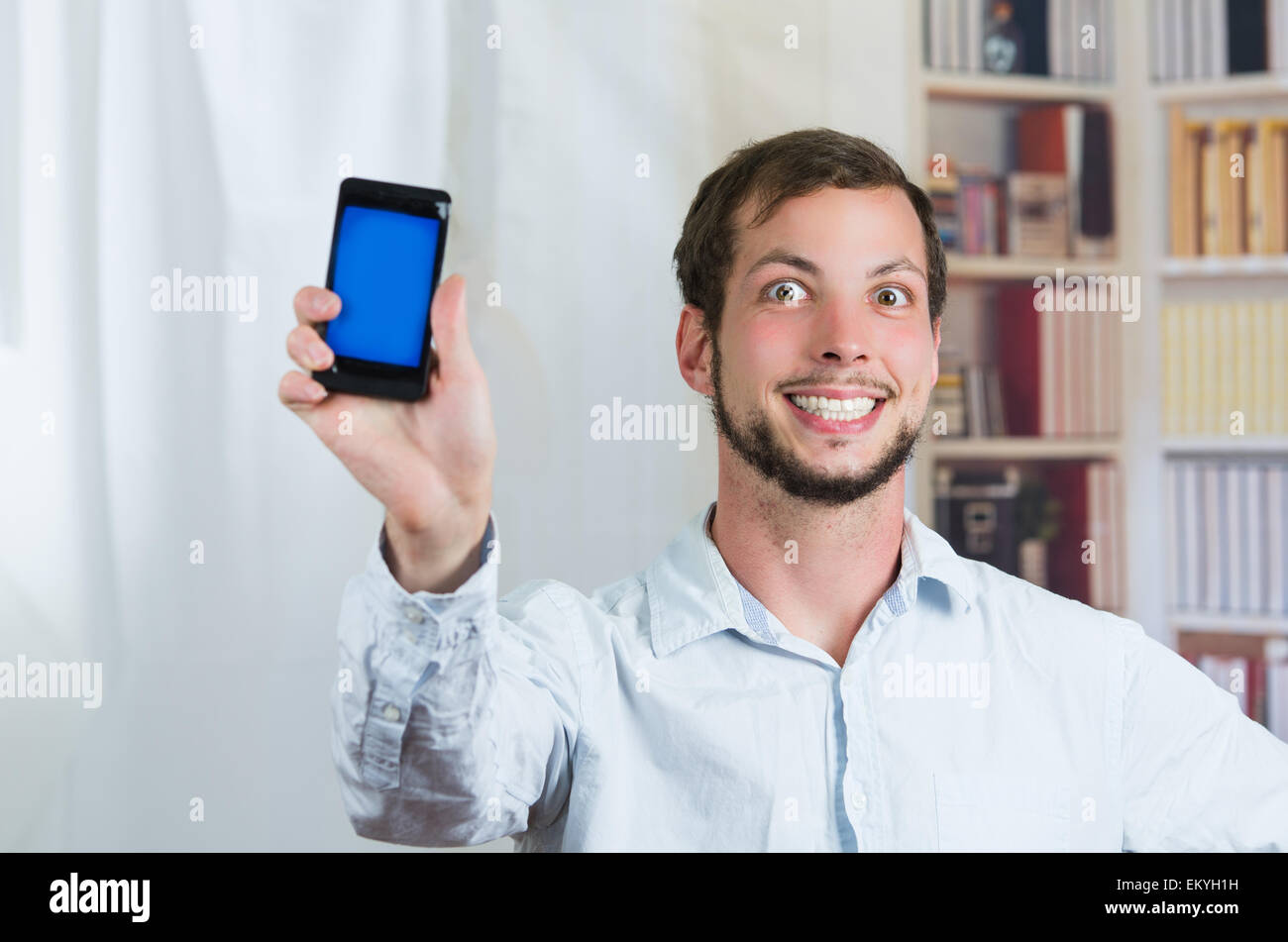 young happy man holding his cell phone and showing the screen Stock ...