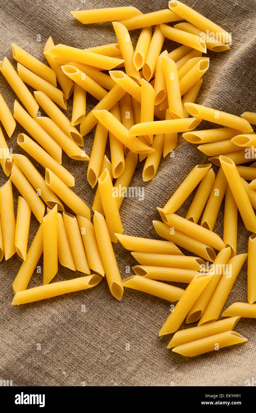 Yellow short macaroni pasta with empty space on hessian fabric cloth ...