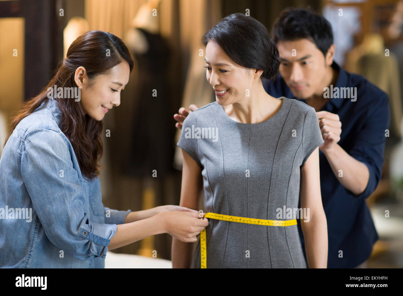 Fashion designers taking measurement of customer Stock Photo - Alamy