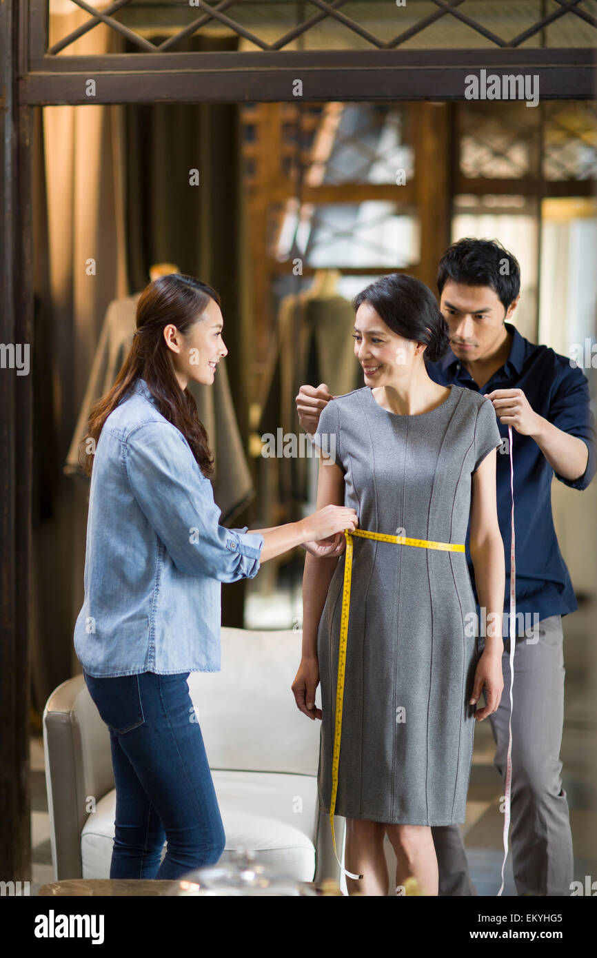 Fashion designers taking measurement of customer Stock Photo - Alamy