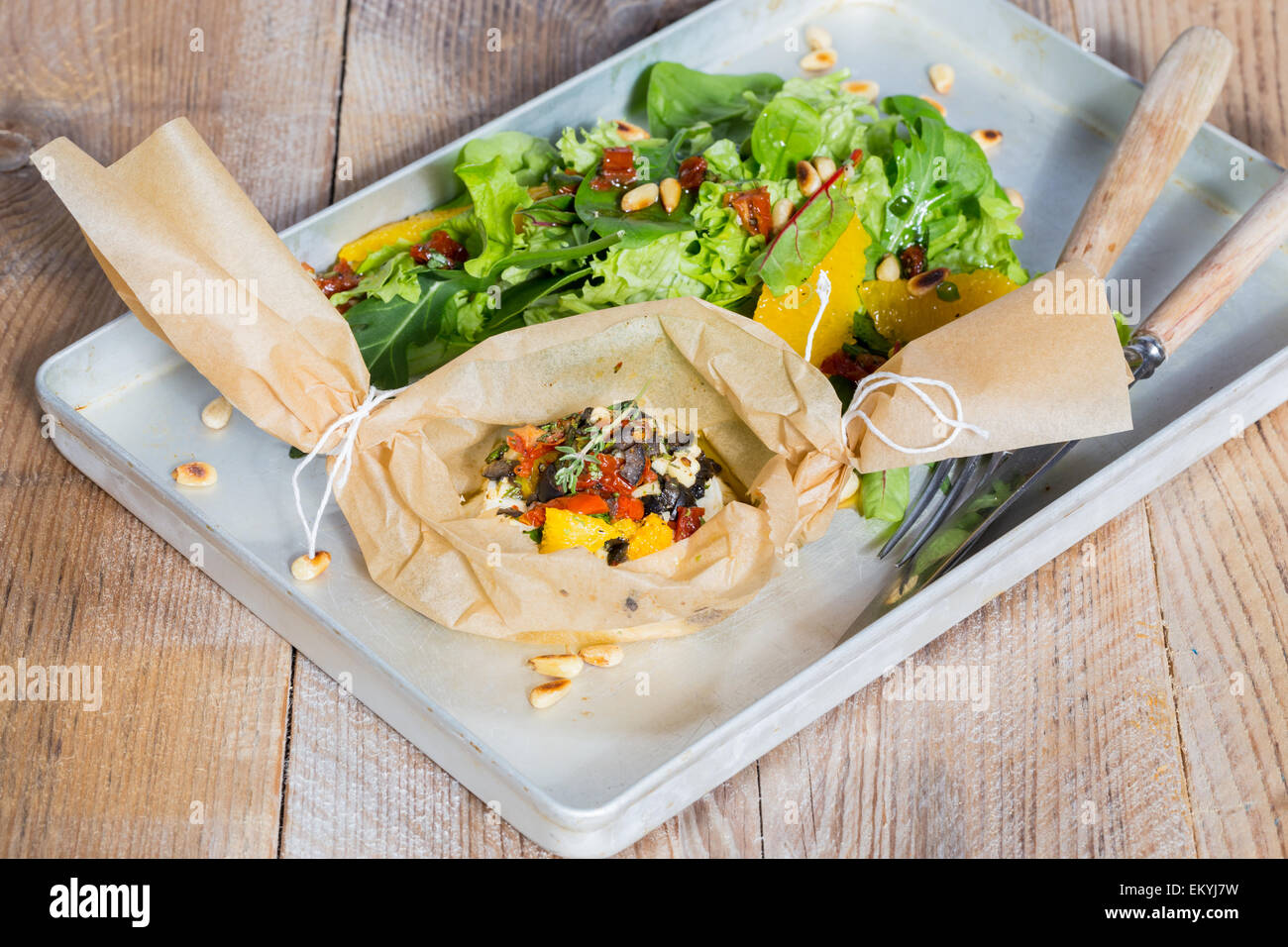 Baked goat cheese Mediterranean in parchment paper Stock Photo - Alamy