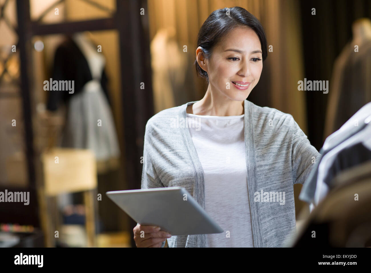 Clothing store owner with digital tablet Stock Photo - Alamy