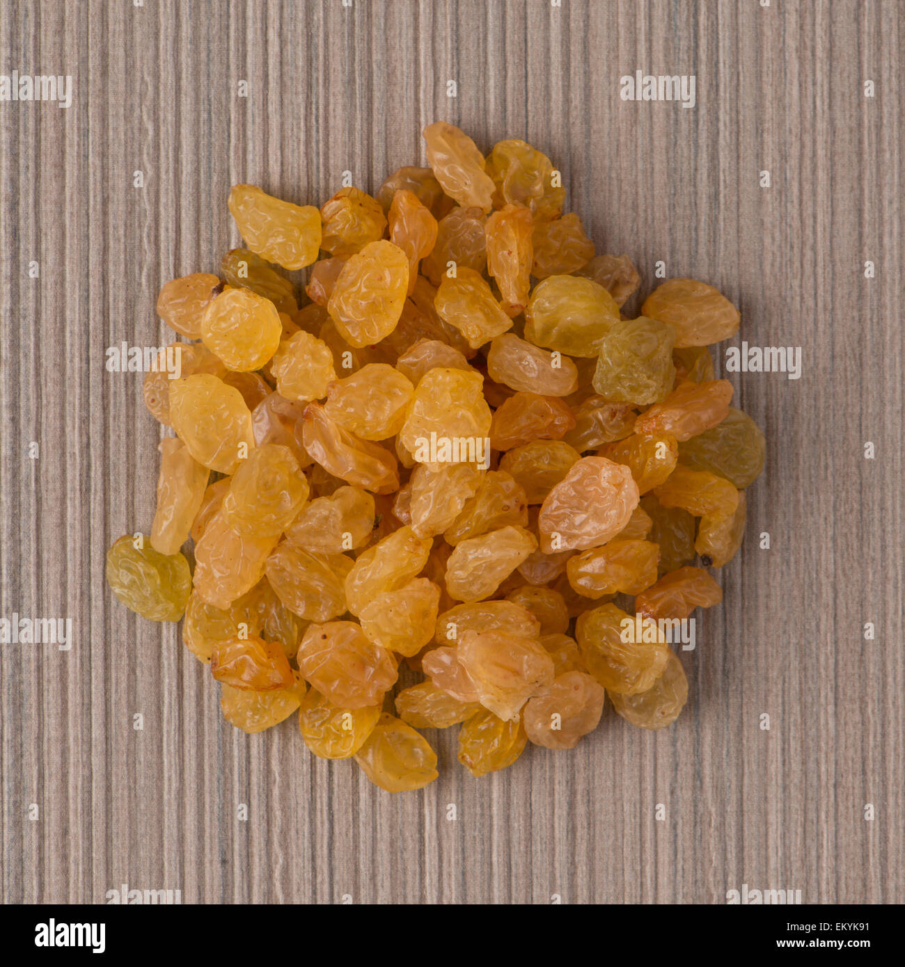 Top view of circle of golden raisins against beige vinyl bacground ...