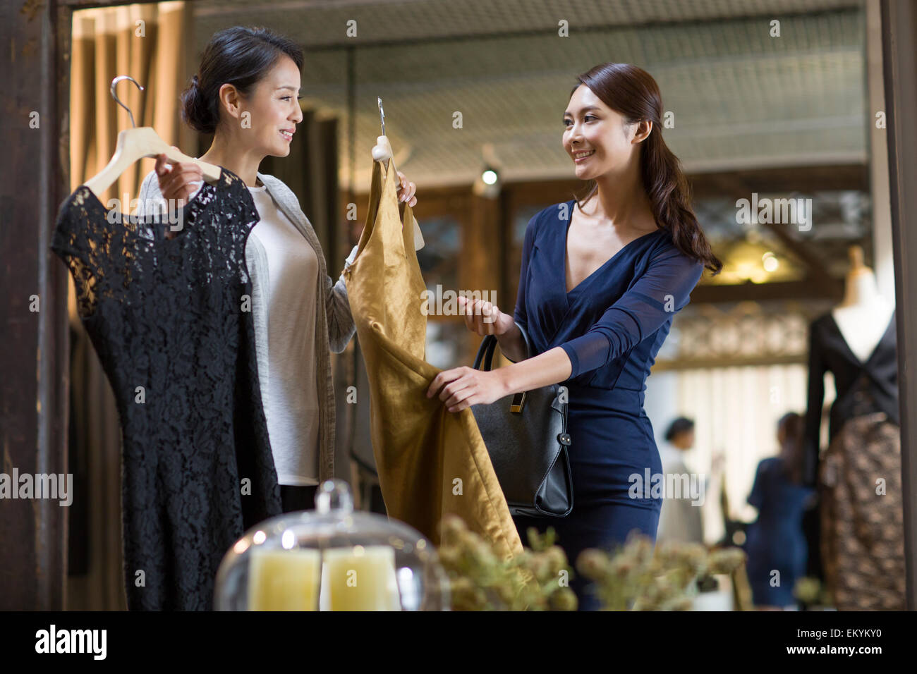 Clothing store owner helping customer with choosing dress Stock Photo ...
