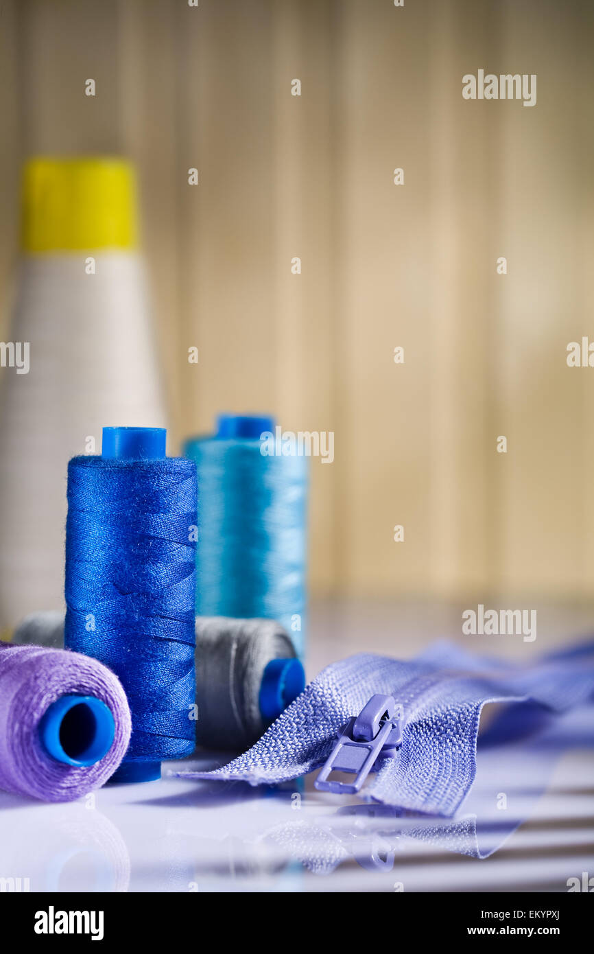 sewing spools and zip on table Stock Photo - Alamy
