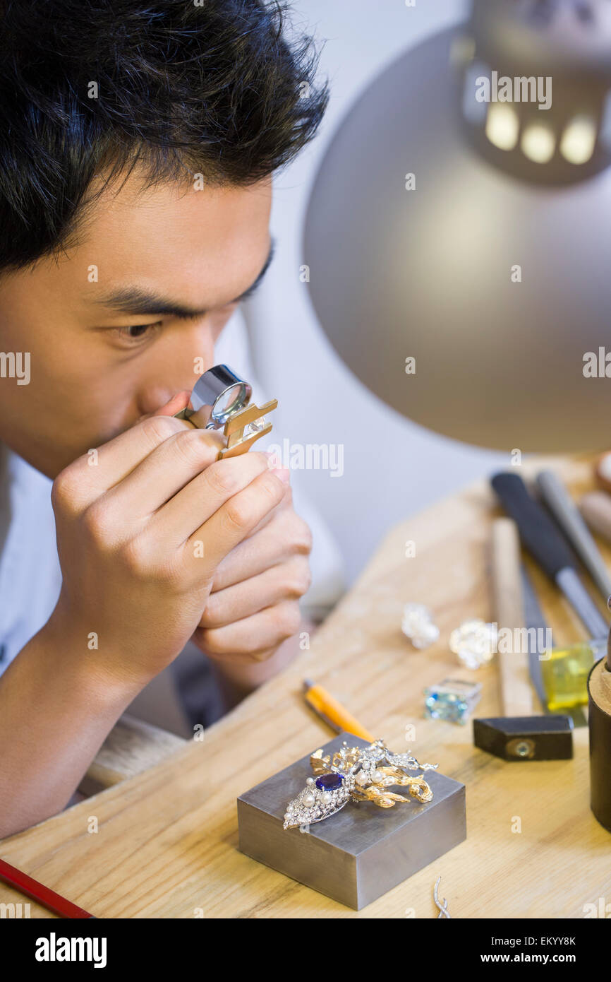Male jeweler examining a diamond with loupe Stock Photo - Alamy