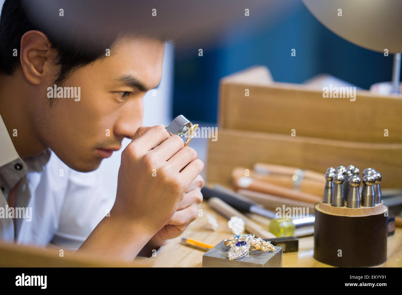 Male jeweler examining a diamond with loupe Stock Photo - Alamy