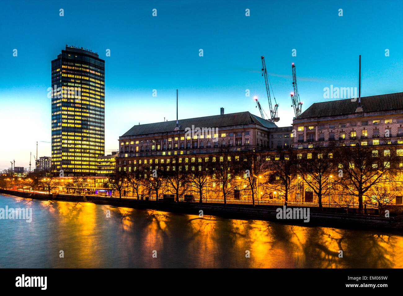 Riverside buildings illuminated during evening in London Stock Photo ...