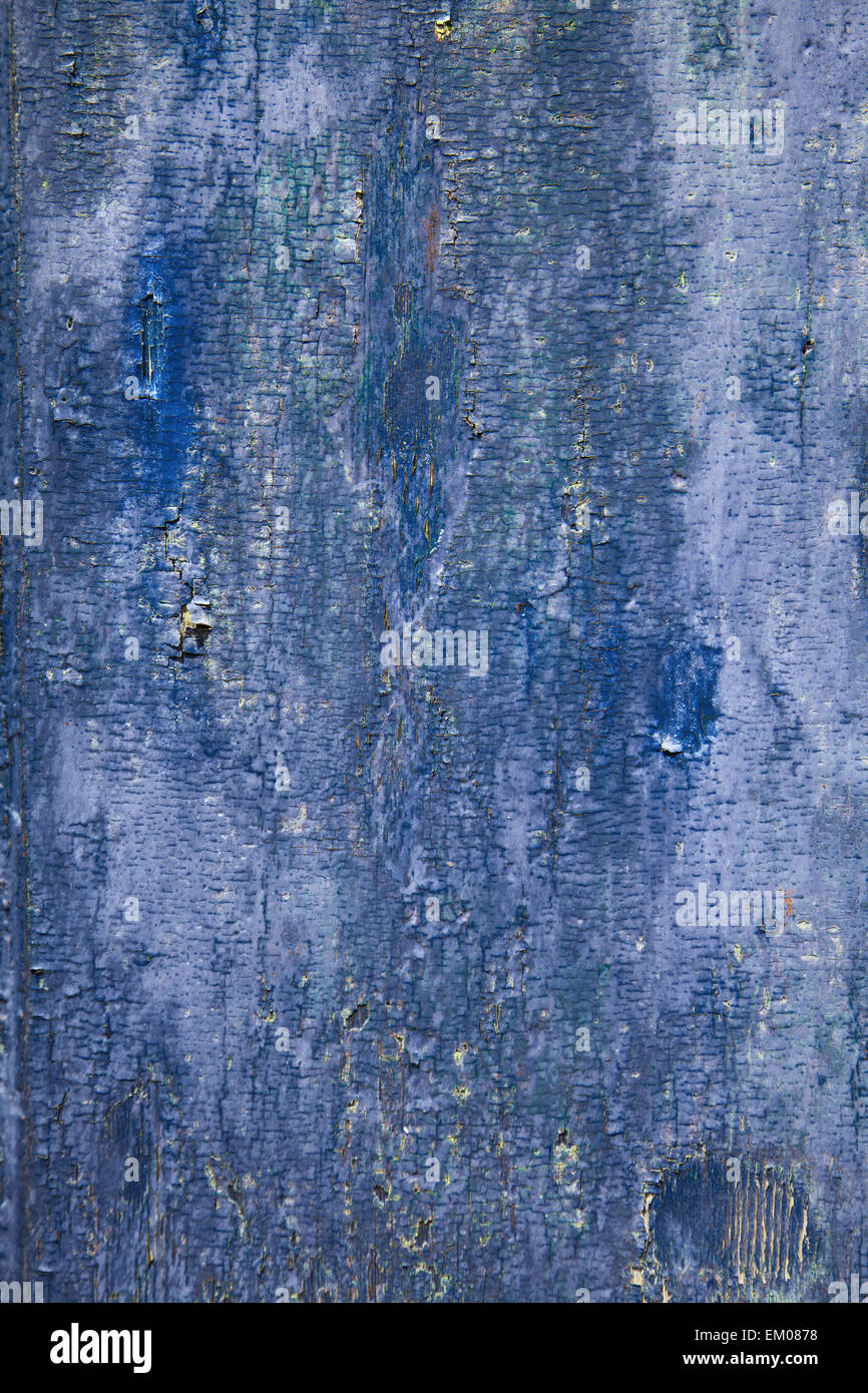 peeling paint over wooden surface, with cracks and different patches ...