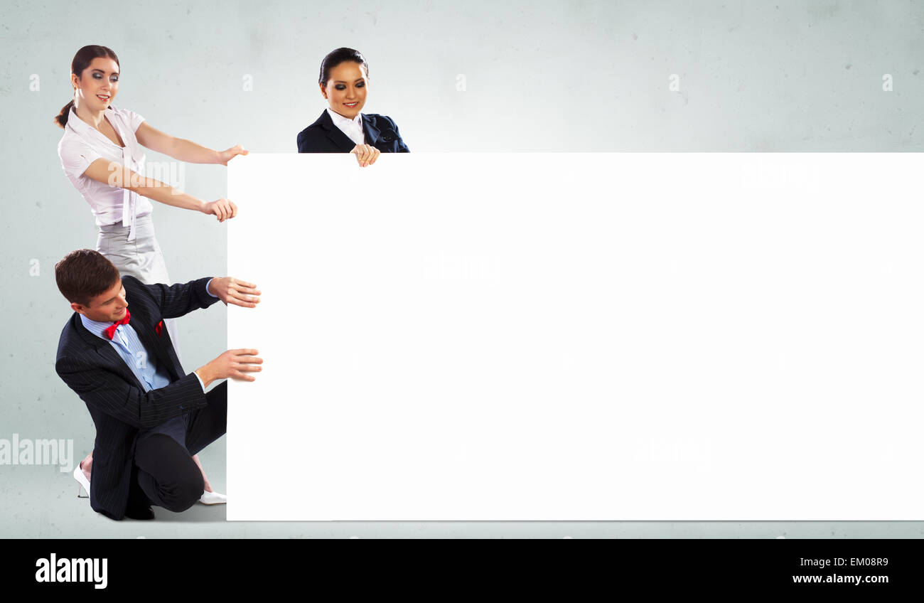 Three young people holding banner Stock Photo - Alamy
