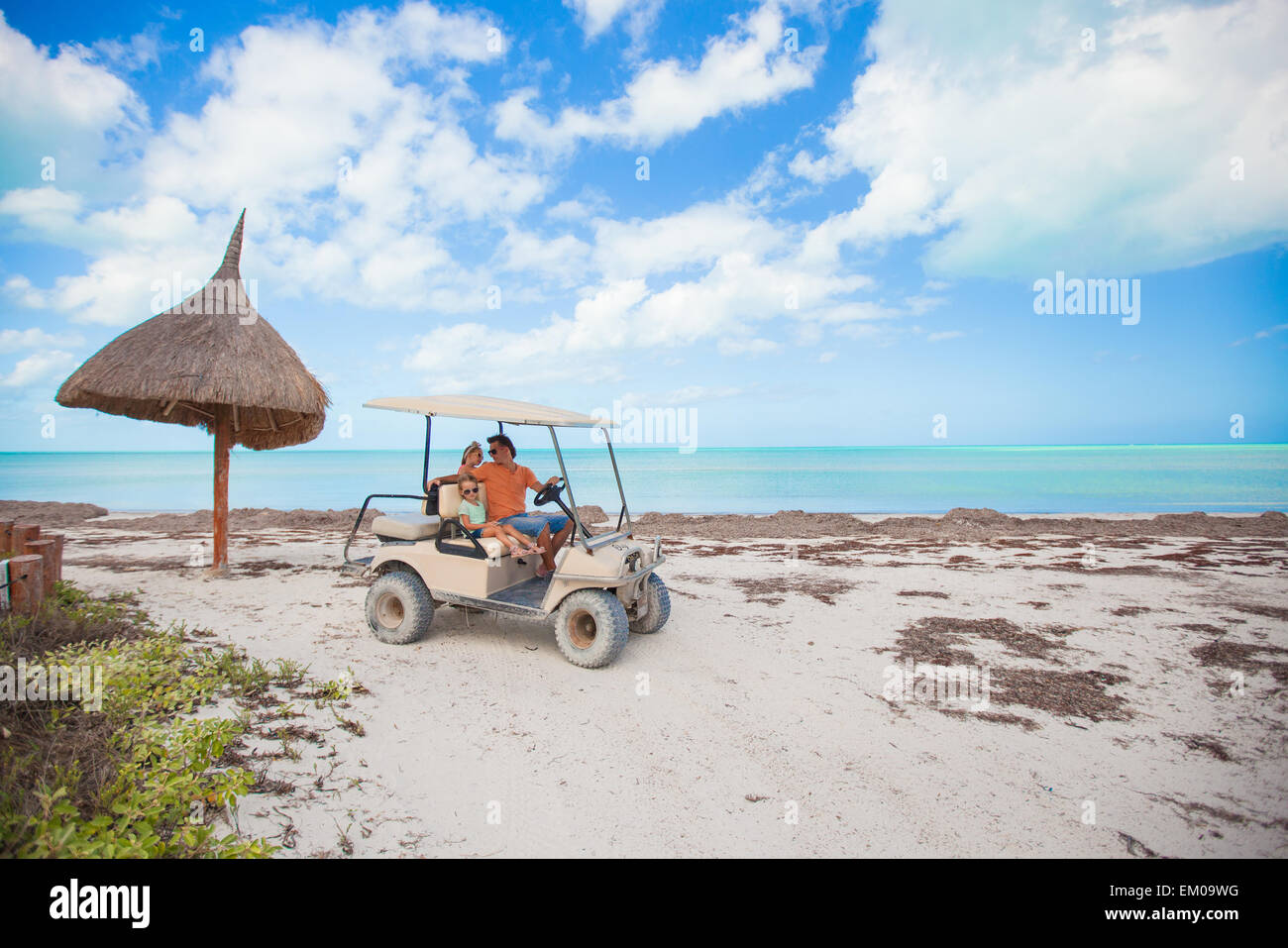 General view golf car with family inside on an exotic beach Stock Photo ...