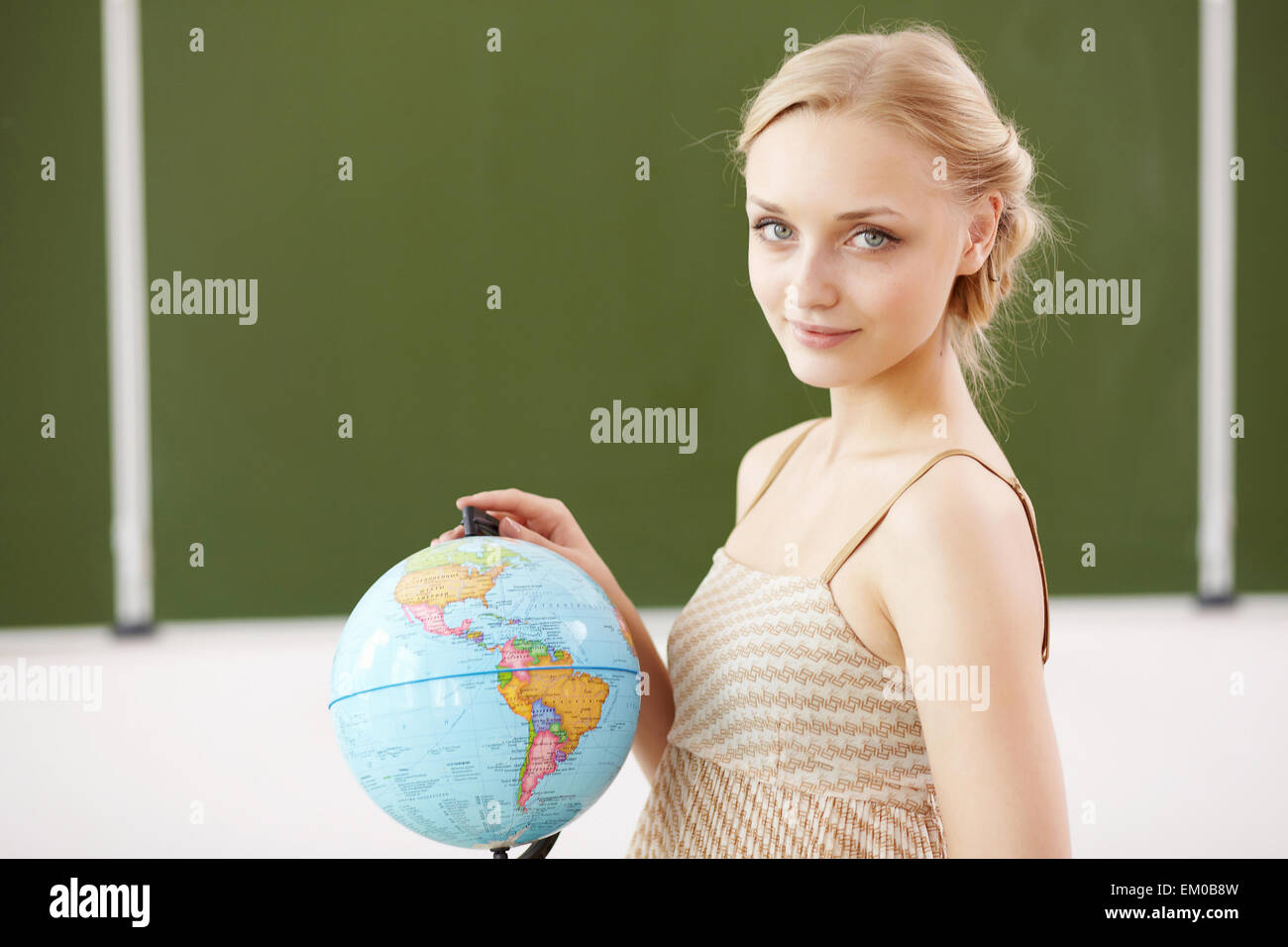 Teacher at school with a globe Stock Photo - Alamy