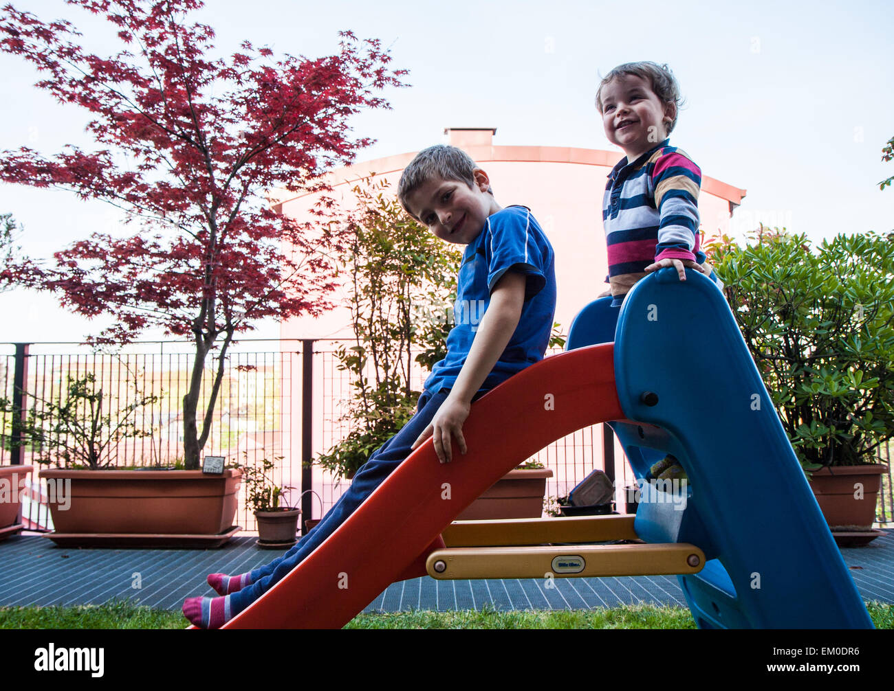Happy kids playing on slide hi-res stock photography and images - Alamy