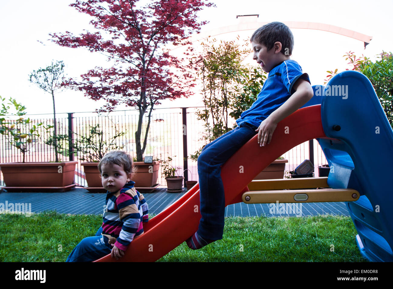 Happy kids playing on slide hi-res stock photography and images - Alamy