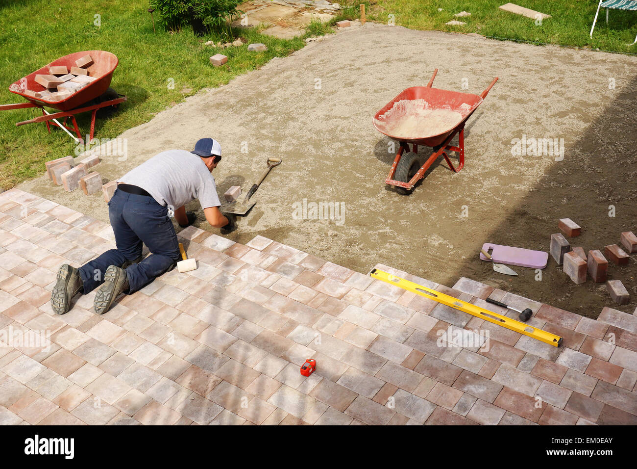 Man laying down paver Stock Photo - Alamy