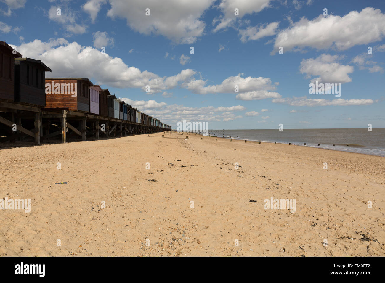 A row of colourful beach huts on a partly cloudy day, in Frinton-on-Sea ...