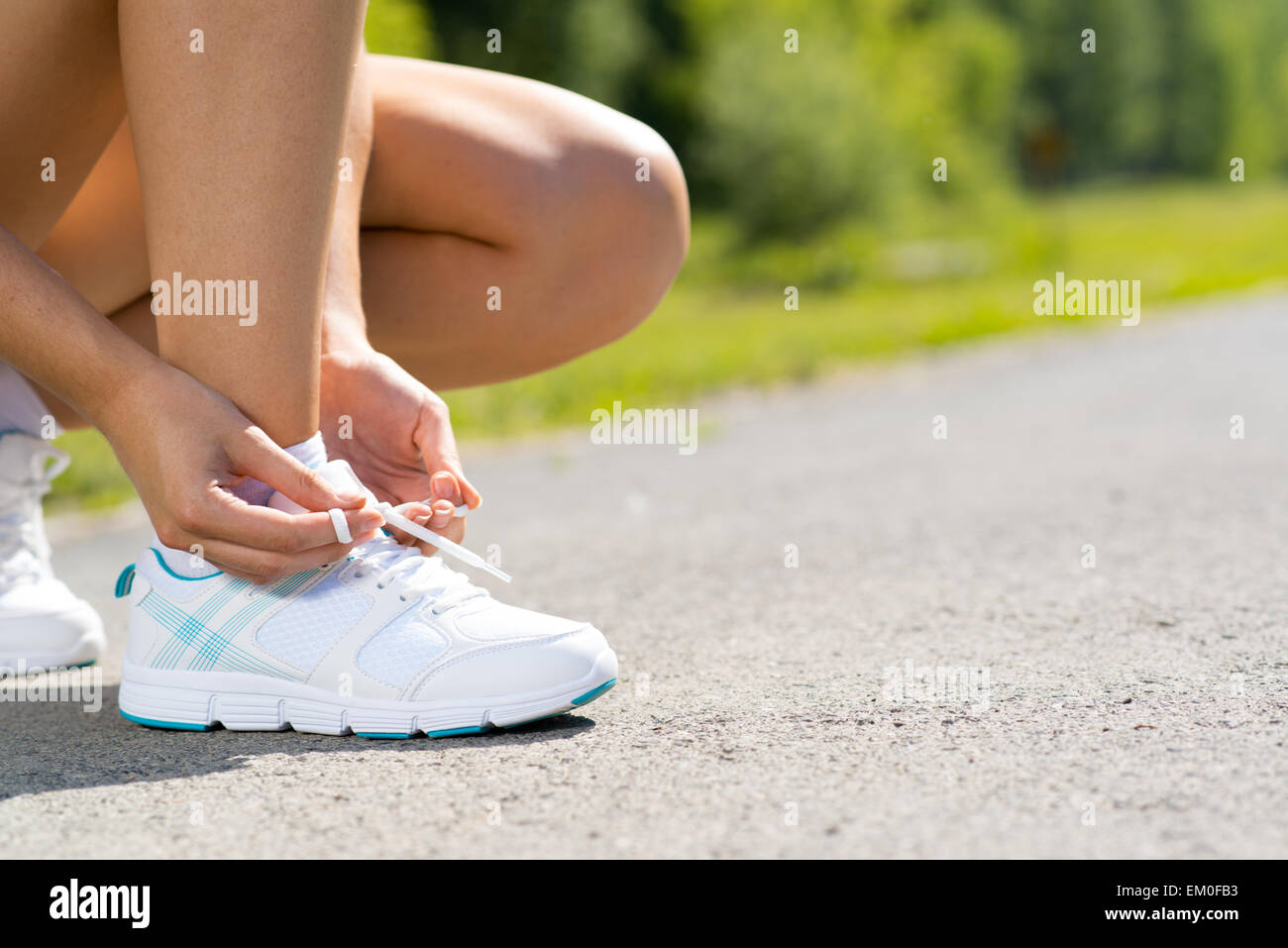 female runner tying lace on sports shoes Stock Photo - Alamy