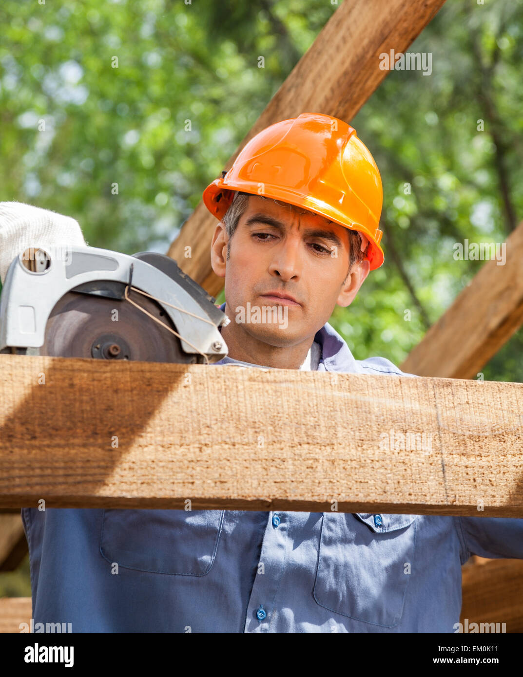 Construction Worker Using Electric Saw On Timber Frame Stock Photo - Alamy