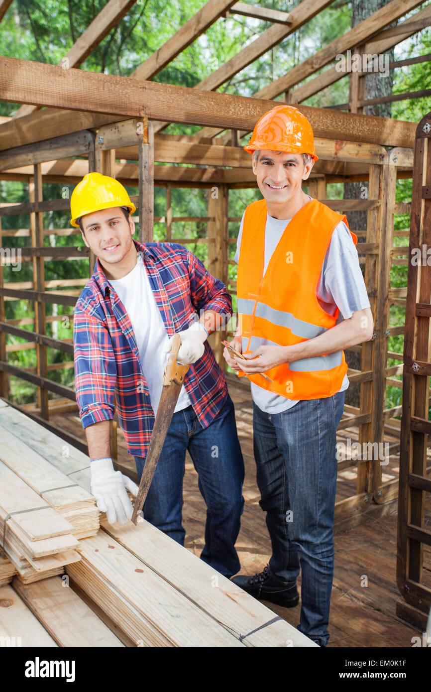 Happy Construction Workers Working At Site Stock Photo - Alamy