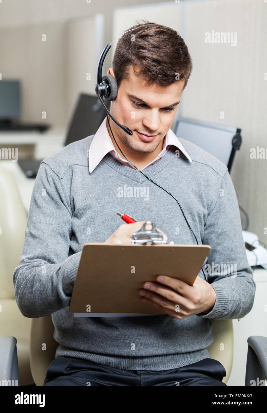 Customer Service Representative Writing On Notepad Stock Photo - Alamy