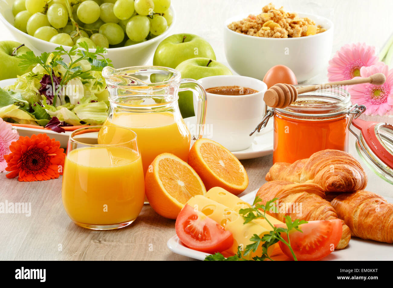 Breakfast consisting of fruits, orange juice, coffee, honey, bread and ...