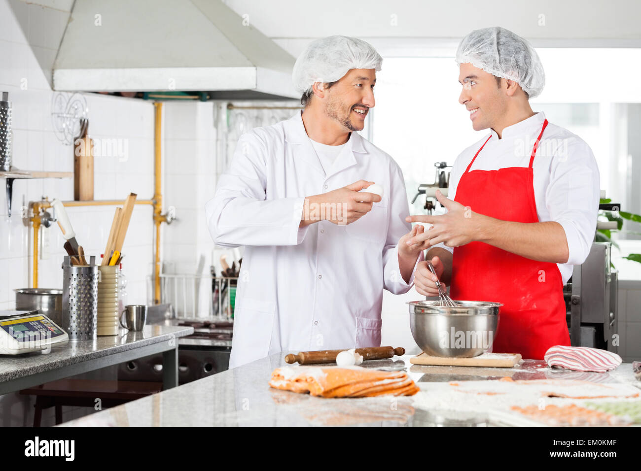 Happy Chefs Discussing While Preparing Ravioli Pasta At Counter Stock ...