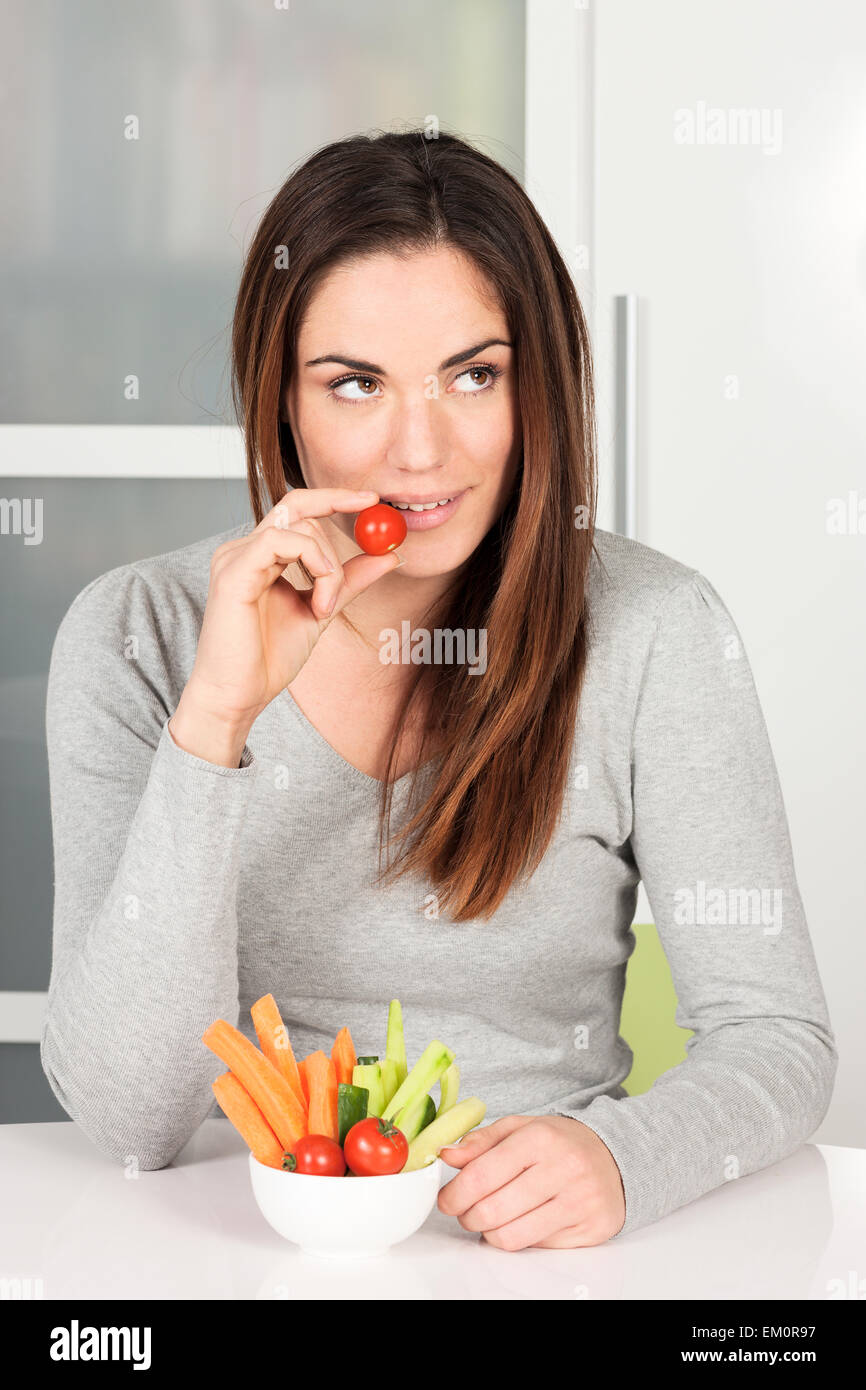 Beautiful girl eating vegetables Stock Photo - Alamy