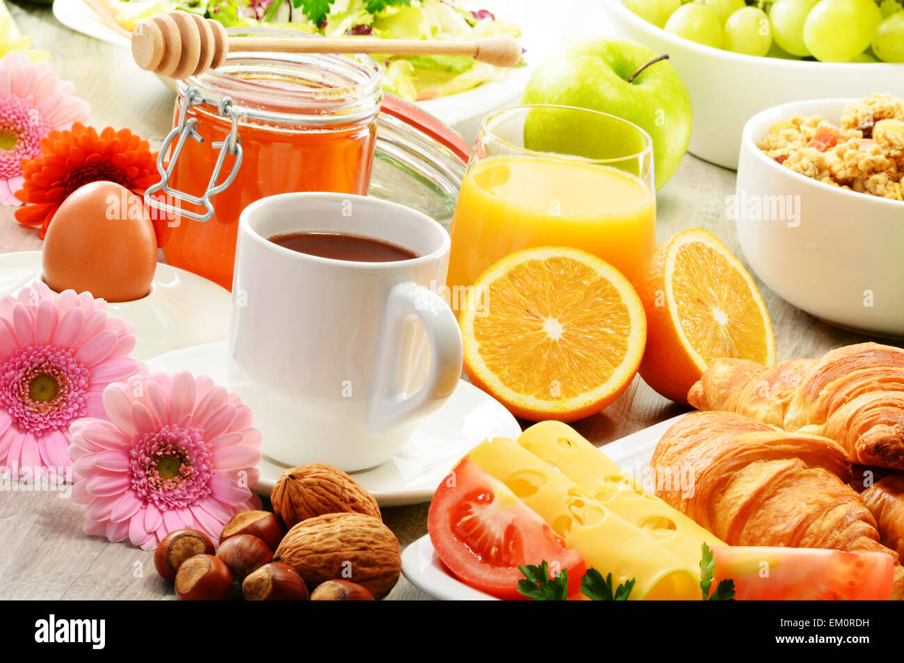 Breakfast consisting of fruits, orange juice, coffee, honey, bread and ...
